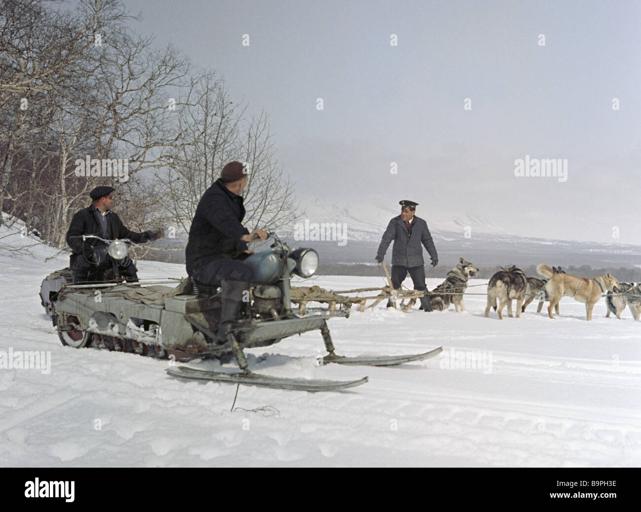 A snowmobile and a dog team basic means of transportation in tundra ...