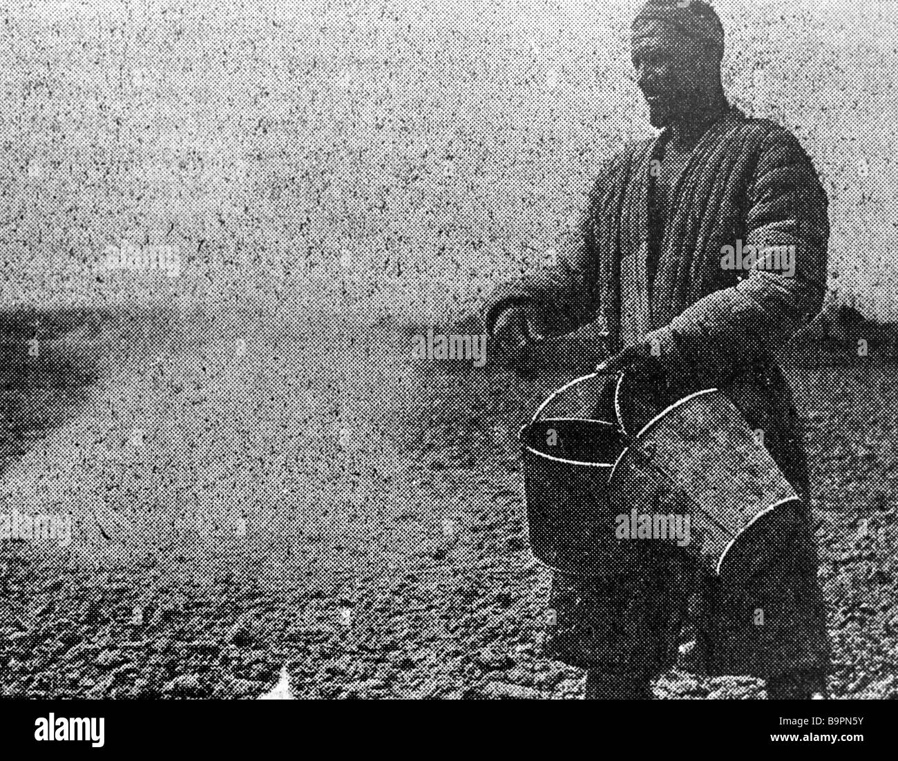 Uzbek farmer spilling fertilizer on cotton field Stock Photo - Alamy