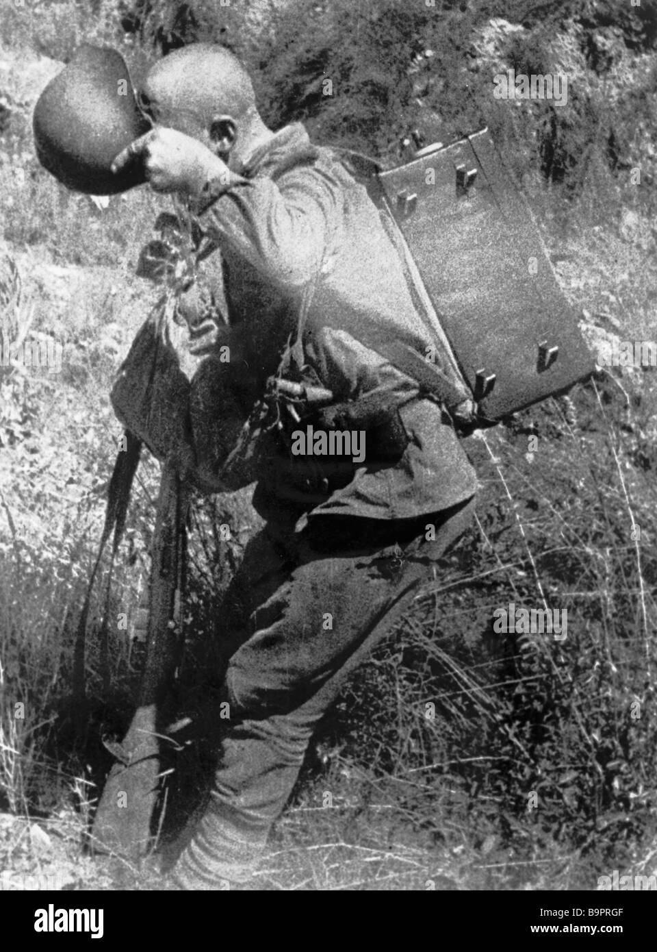 A Soviet soldier drinking water from the helmet after a battle Stock ...
