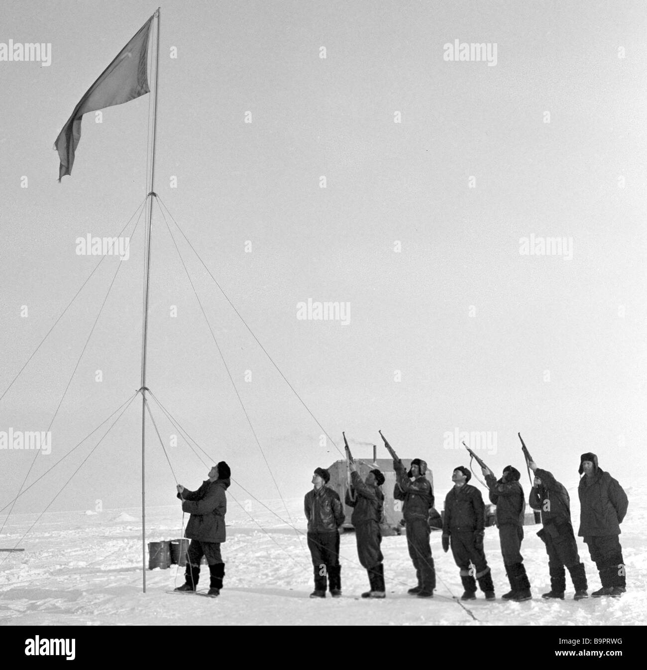 Arctic explorers hoisting flag over the North Pole 12 station on the ...