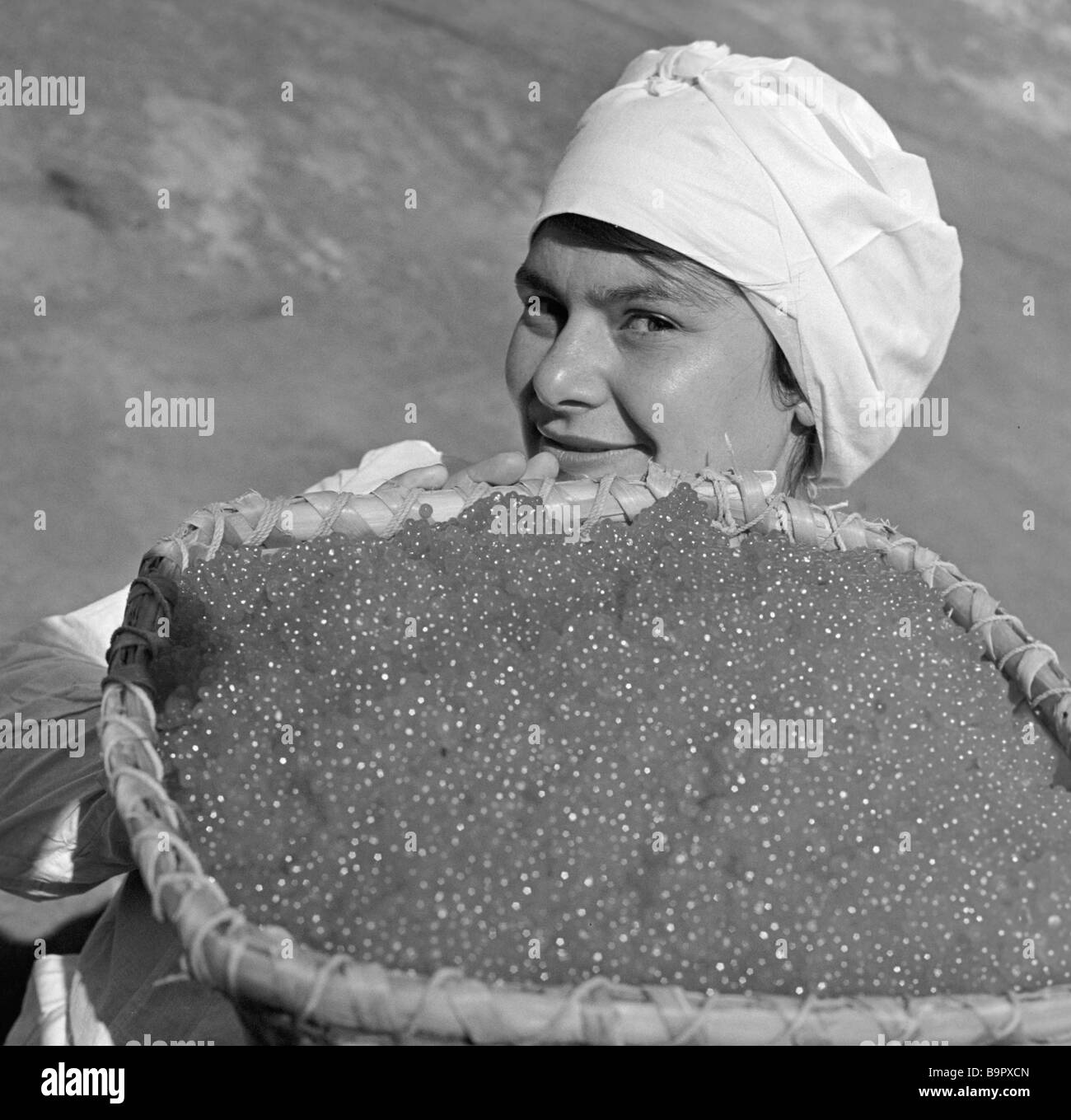 A female worker from the Ust Kamchatsk fishery factory carrying a ...