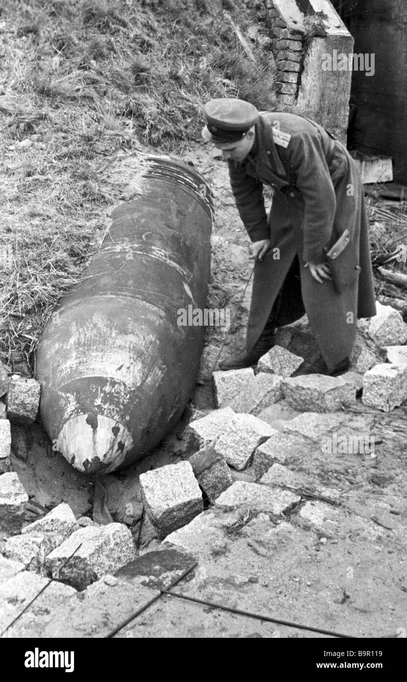 A Soviet officer examining an unexploded shell Stock Photo - Alamy