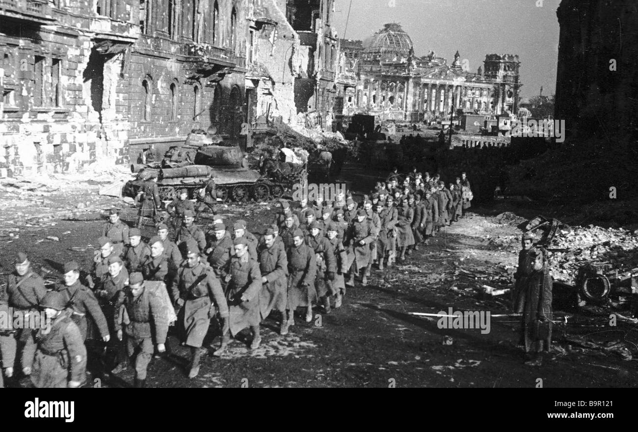 Soviet soldiers marching along a Berlin street ready to return home ...