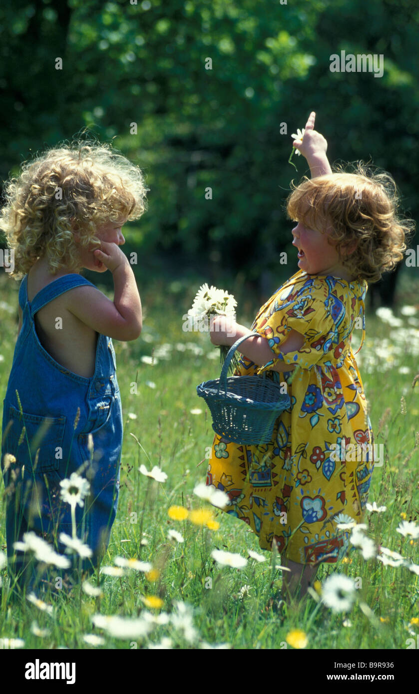 two toddlers playing in spring meadow Stock Photo - Alamy