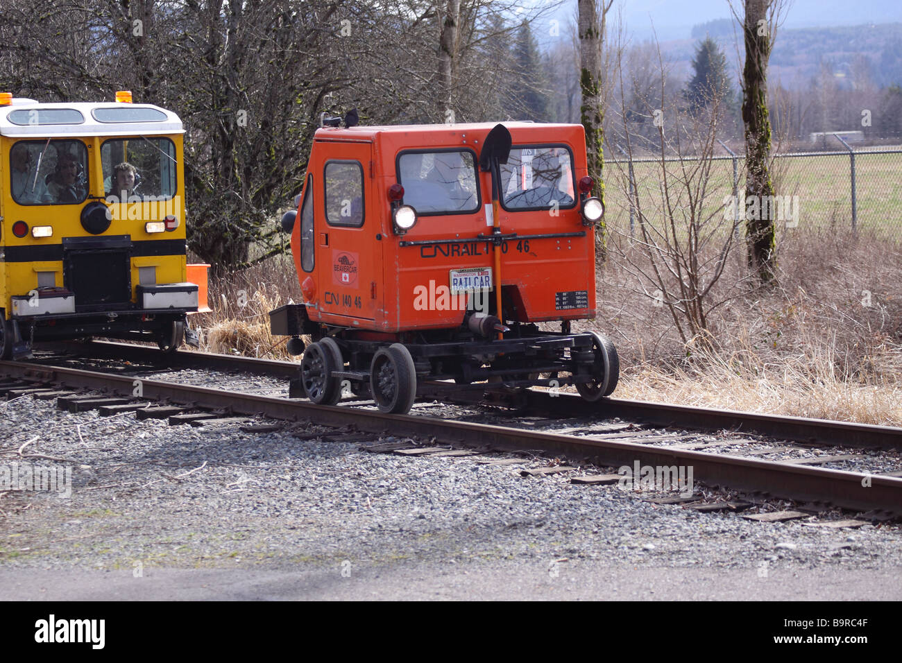 A couple of different railcars driving down the railroad tracks in the ...