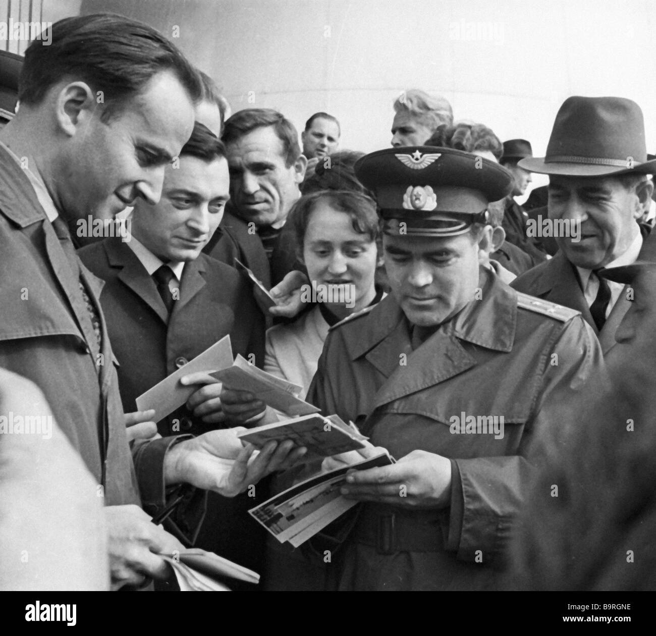 Pilot cosmonaut Andrian Nikolayev center giving autographs at the ...