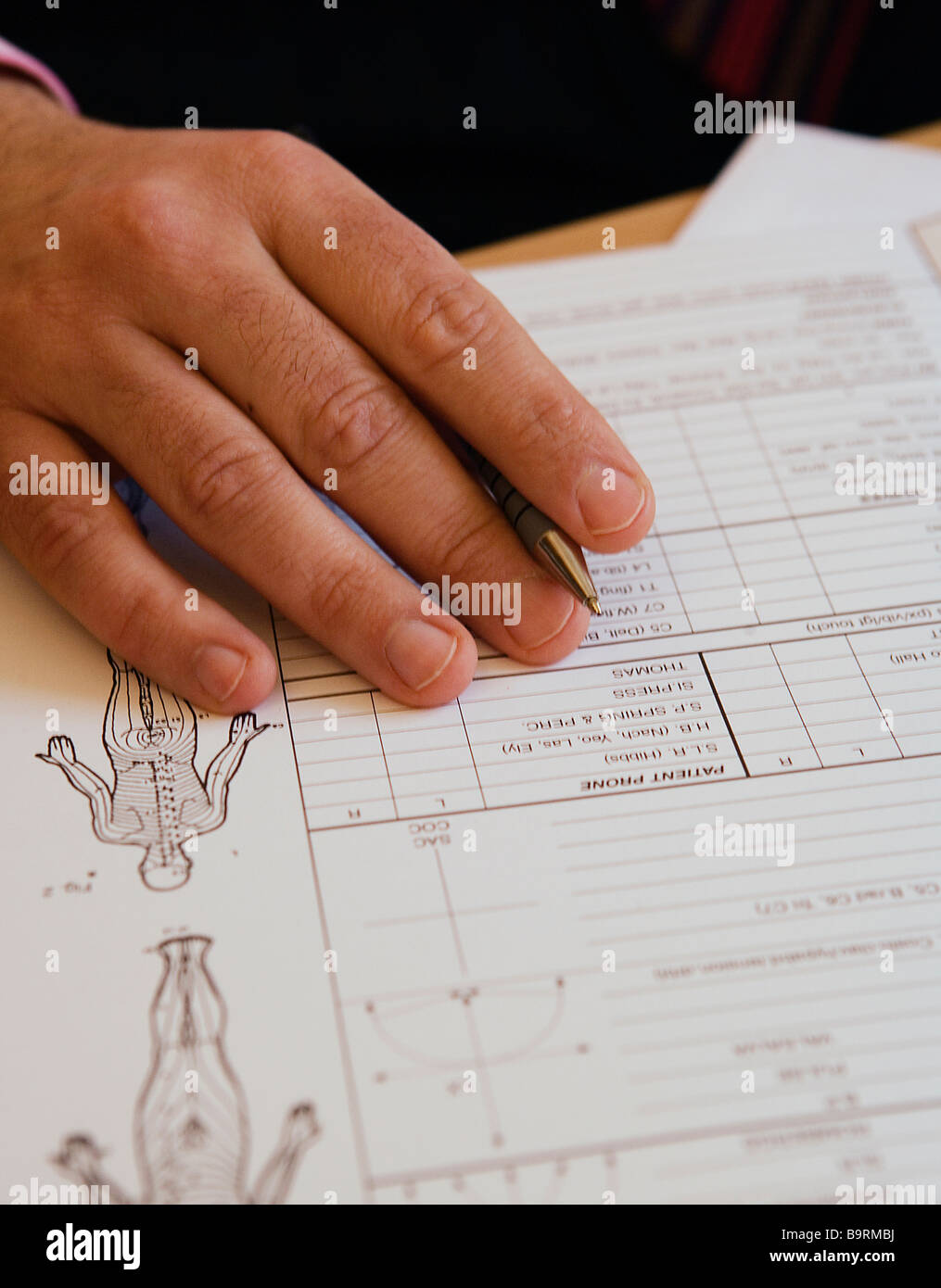 A chiropractor studies patient notes Stock Photo - Alamy