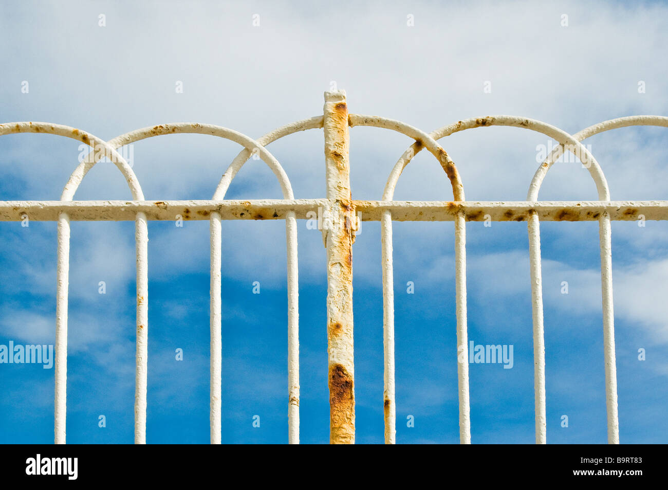 Rusting iron railings against a blue and cloudy sky Stock Photo - Alamy