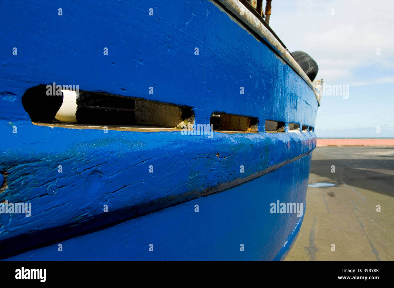 The blue painted hull of a wooden fishing boat Stock Photo - Alamy