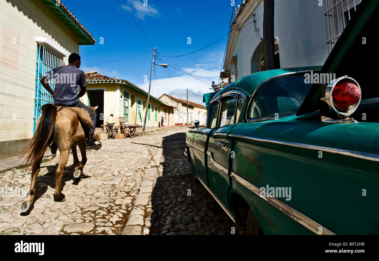 A Cuban cowboy sits atop his horse and rides through the streets of ...