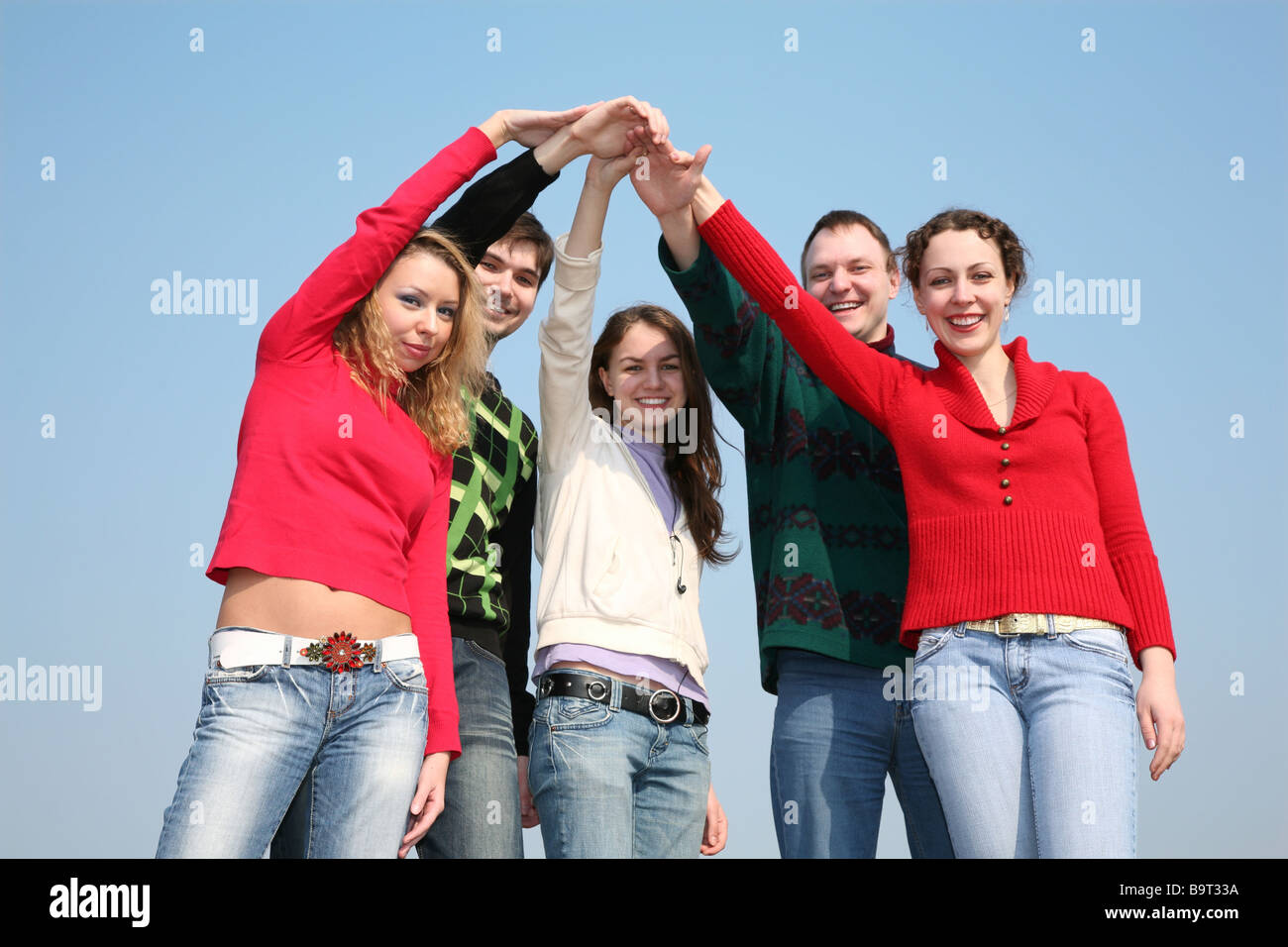 people hold hands on sky background Stock Photo - Alamy
