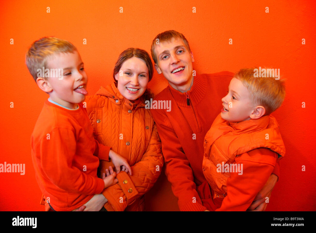 Family together on an orange background Stock Photo - Alamy