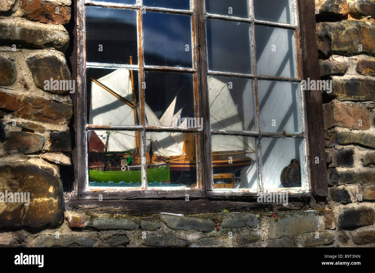 Old wooden model boats sit in the window of a Cornish fishing village ...