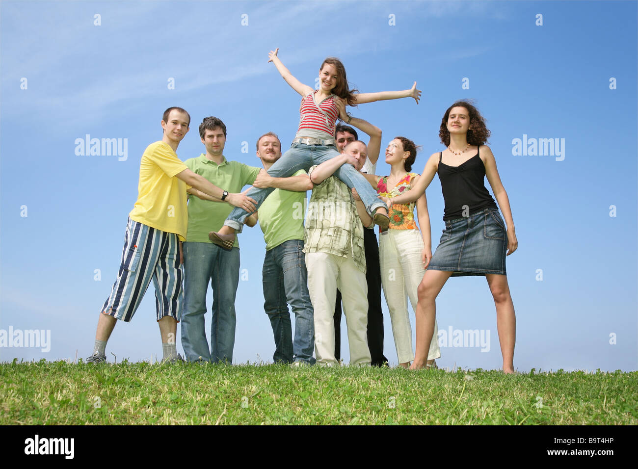 Friends have lifted the girl upwards Stock Photo - Alamy
