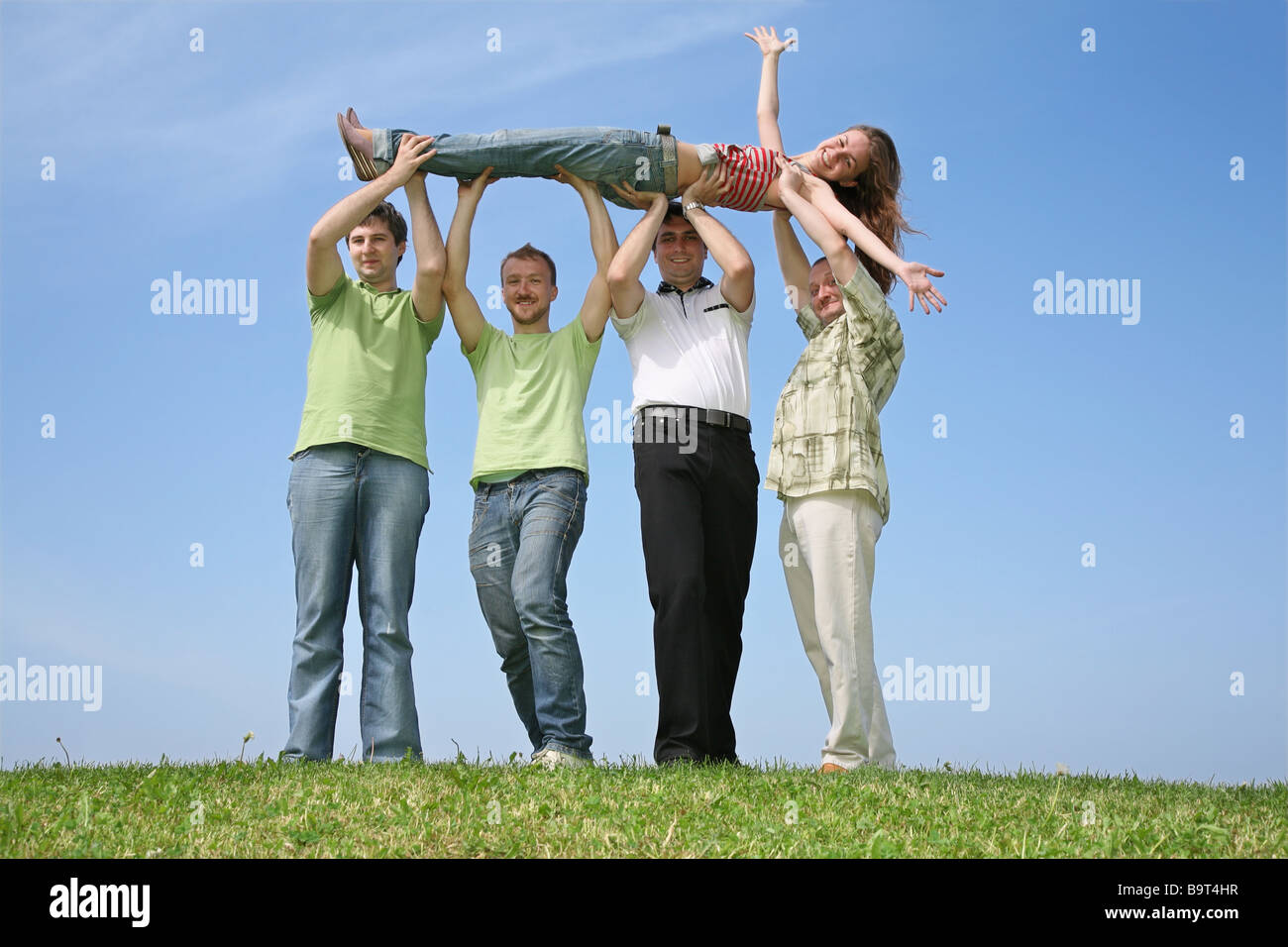Four friends have lifted the girl upwards Stock Photo - Alamy