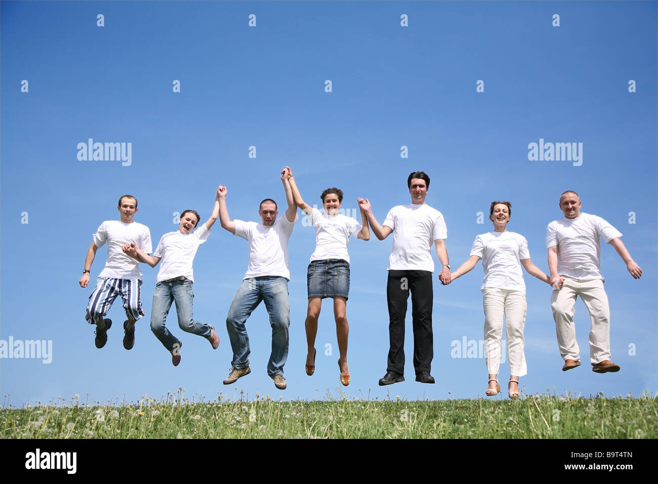 Group of friends in white T-shirts jump together Stock Photo - Alamy