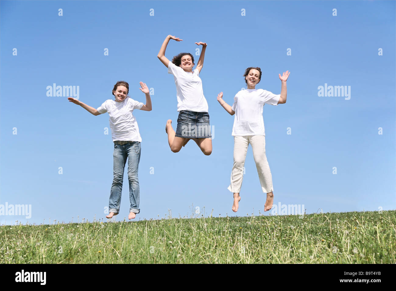Three girlfriends in white T-shirts jump together Stock Photo - Alamy