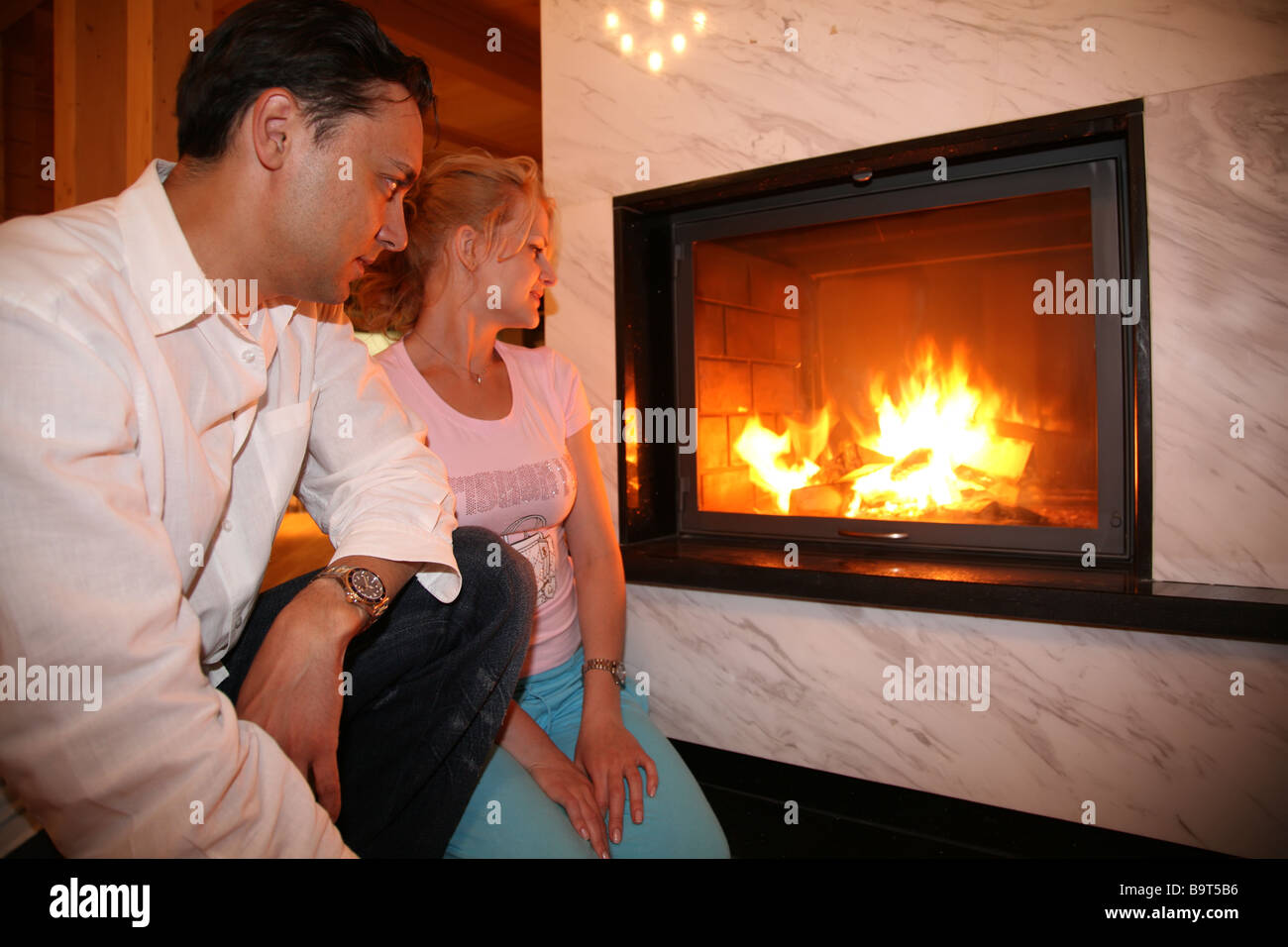 man, woman and fireplace Stock Photo - Alamy