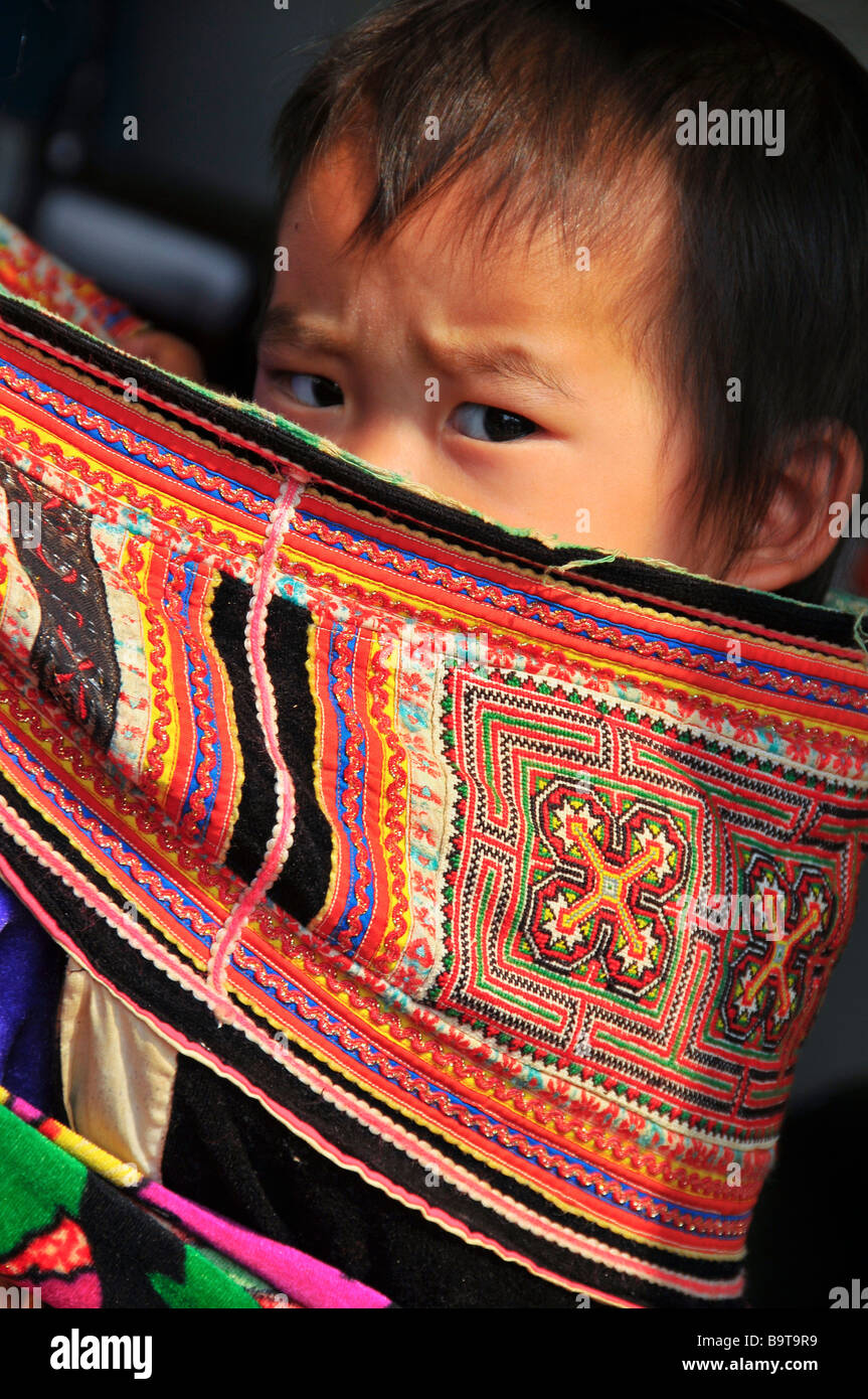 young Hmong boy being carried on his mothers back near Sapa Vietnam ...