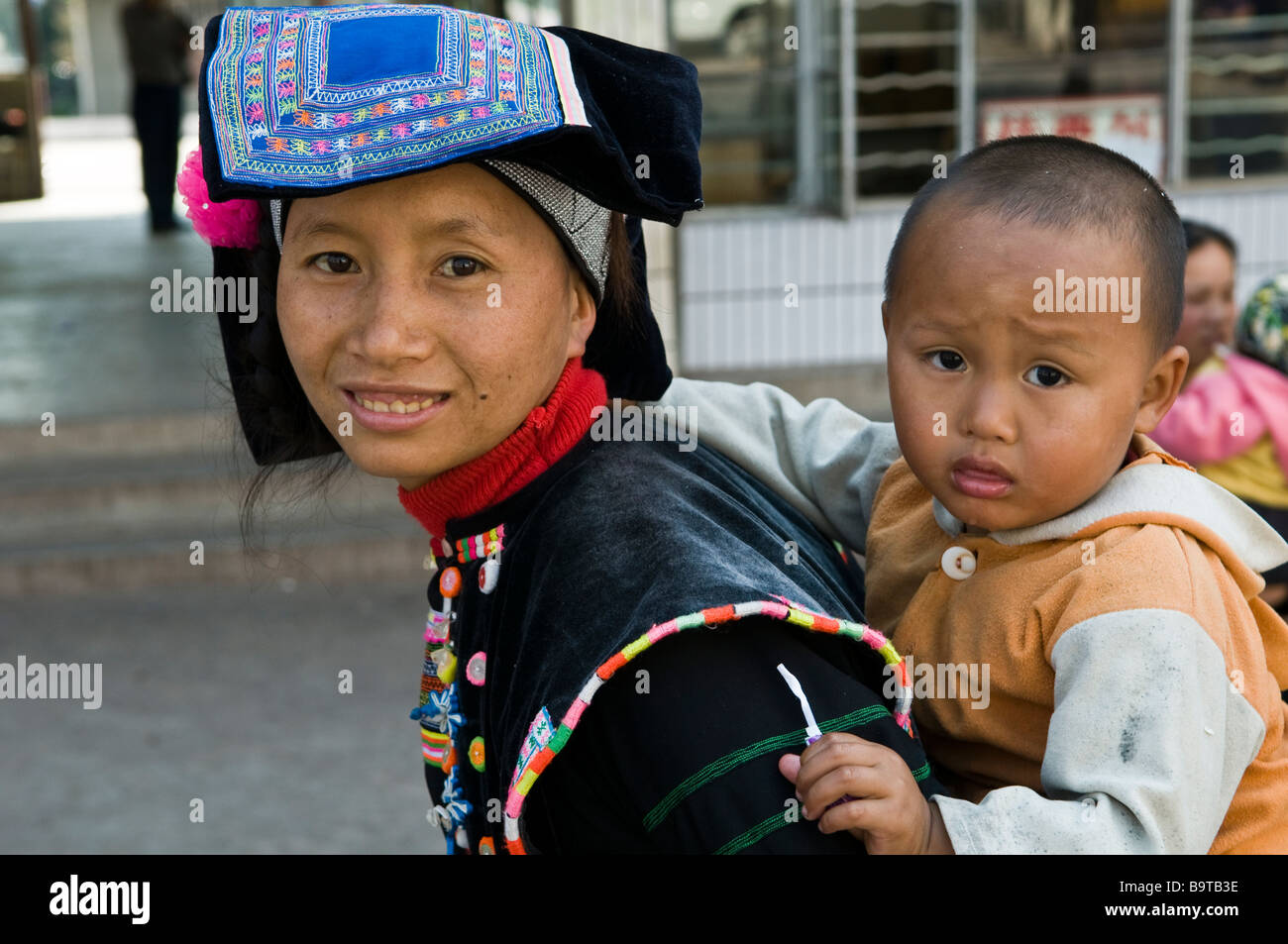 A smiling Yi woman and her child. this woman is from the Alu branch of ...