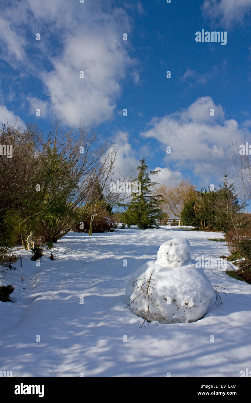 Snowman in sunny garden Stock Photo - Alamy