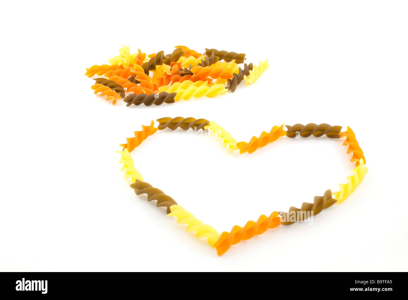 multicolored pasta heart lined on a white background Stock Photo - Alamy