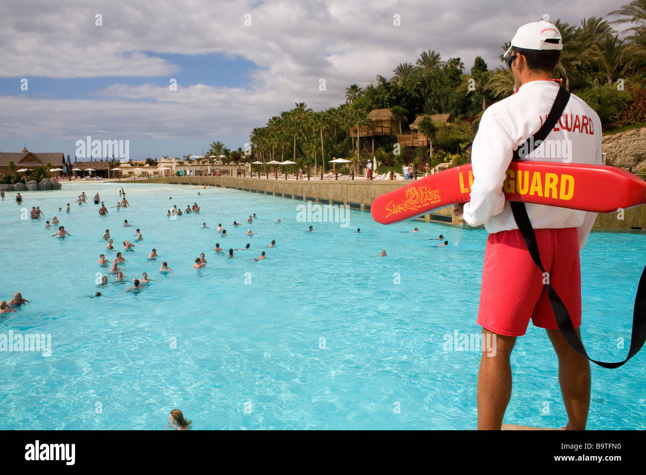 A male life guard watches over visitors swimming in the wave pool at ...