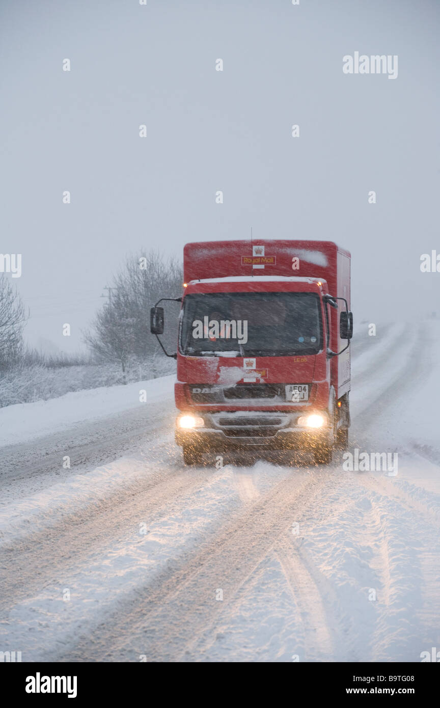 Royal mail lorry driving along a snow covered road in England in winter ...