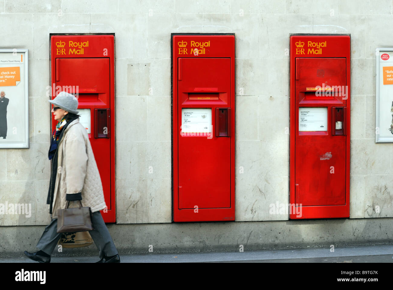 Postal boxes with person passing by Stock Photo - Alamy