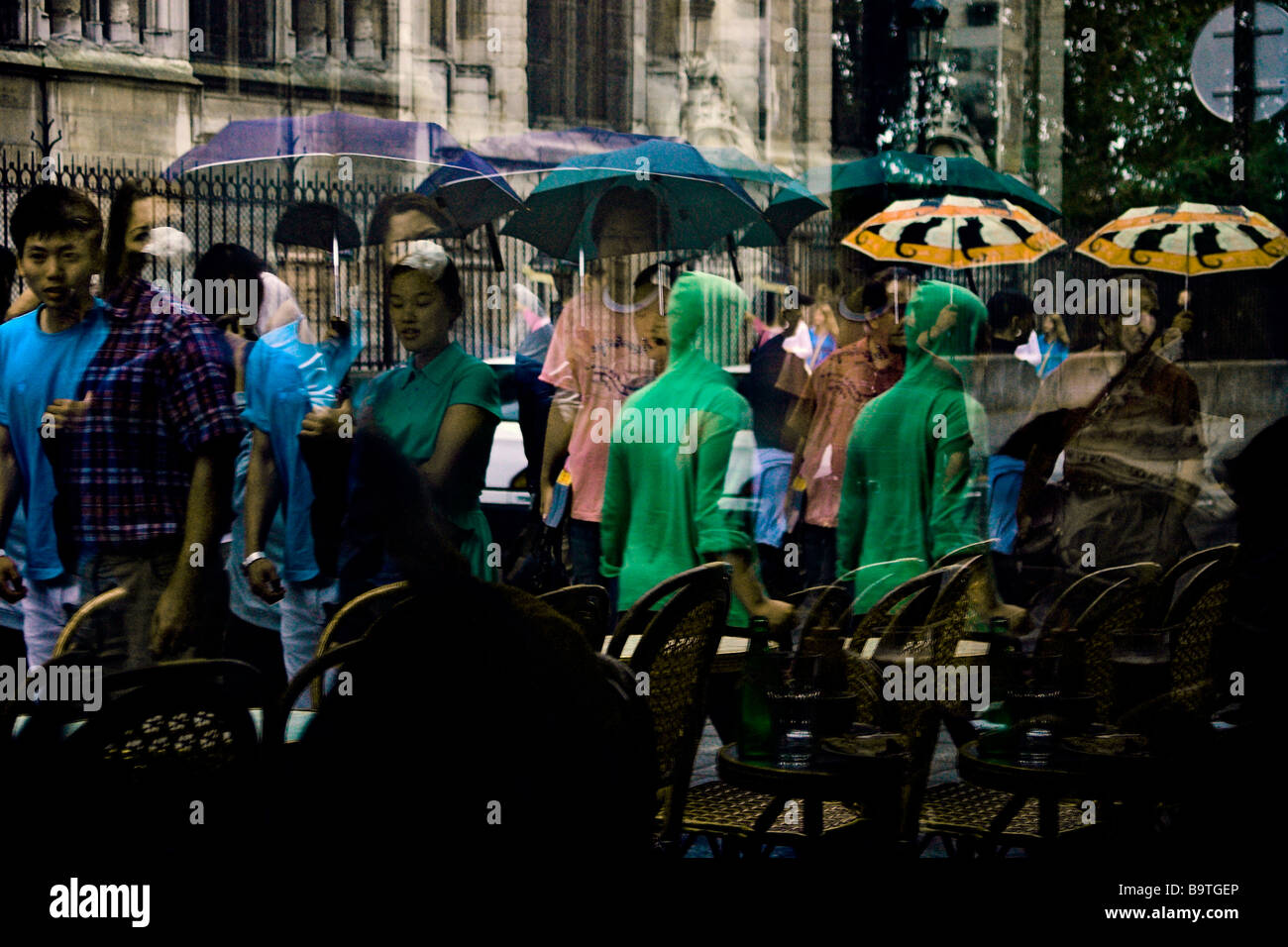 reflections in window of crowd and umberellas on a rainy day in paris ...