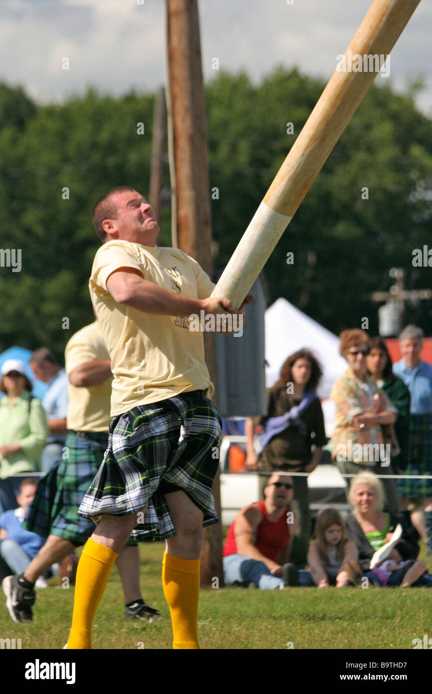 A man participates in the caber toss athletic competition at a Celtic ...