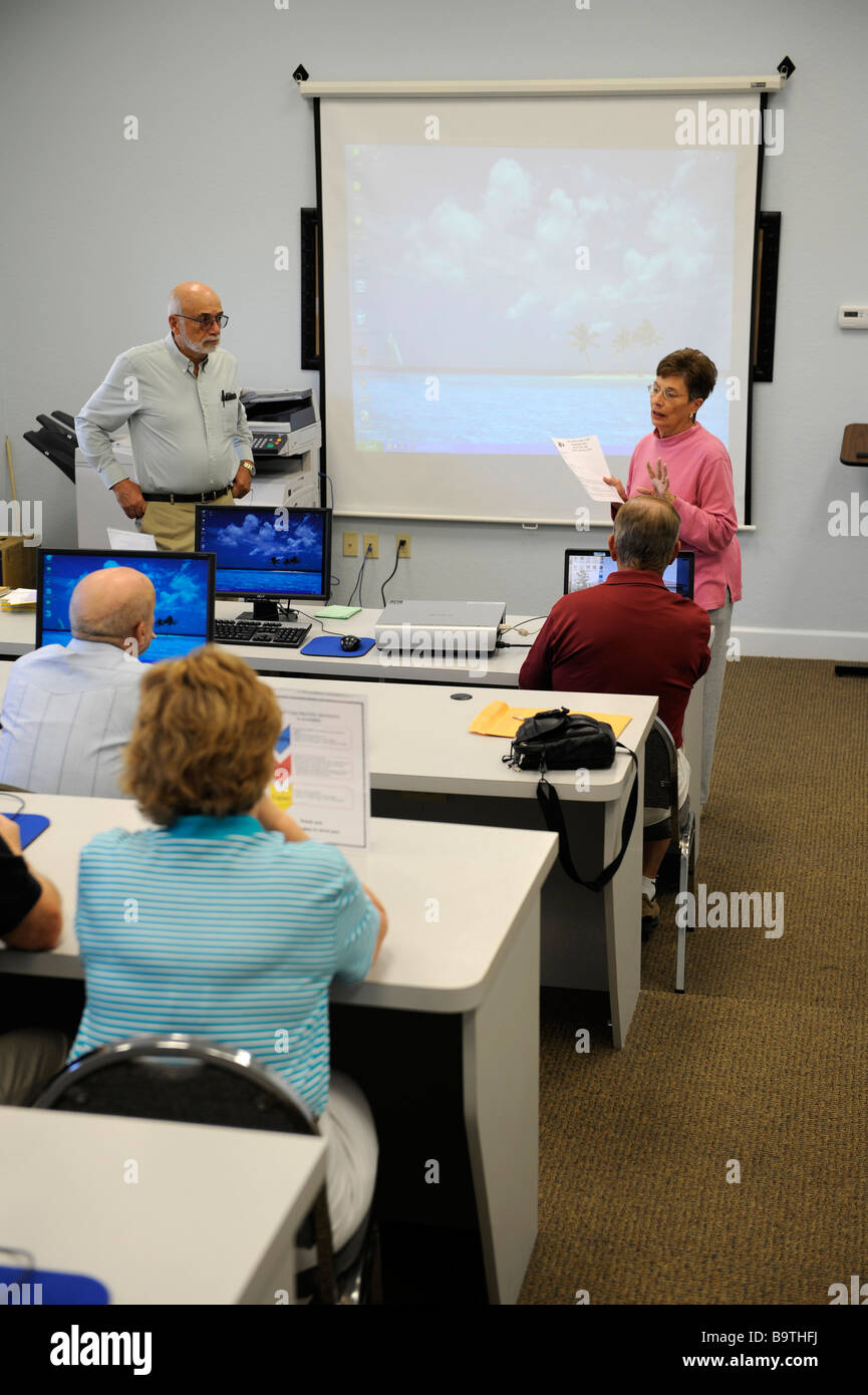 Adult Men and Women using technology in computer learning center Stock ...