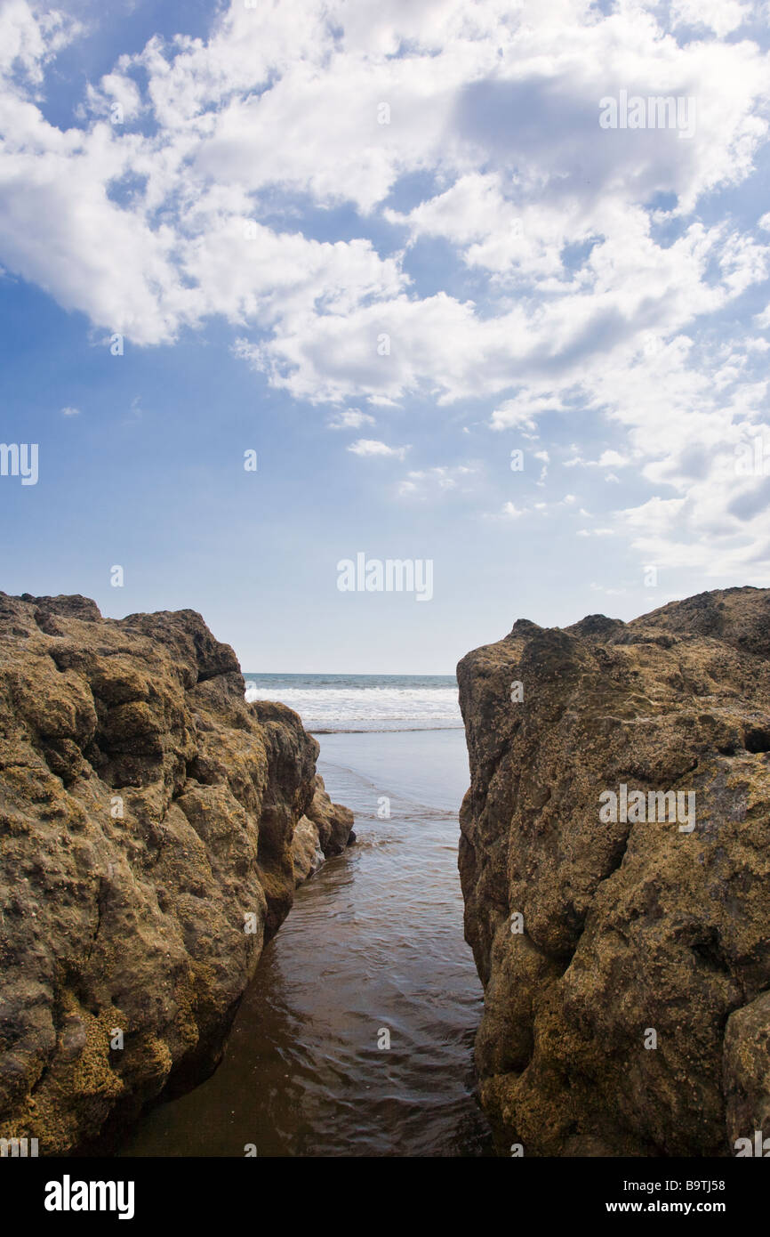 Ocean washing between rocks on Playa Jaco beach in the Puntarenas ...