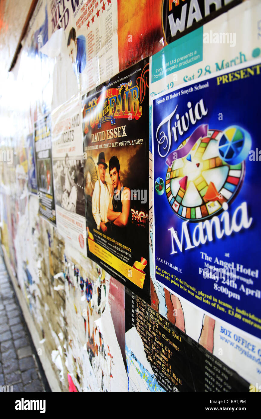 A narrow alleyway covered in theatre posters and advertising flyers ...