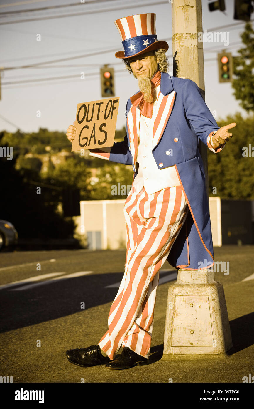 Uncle Sam on the side of the road holding a Out of Gas sign Stock Photo ...