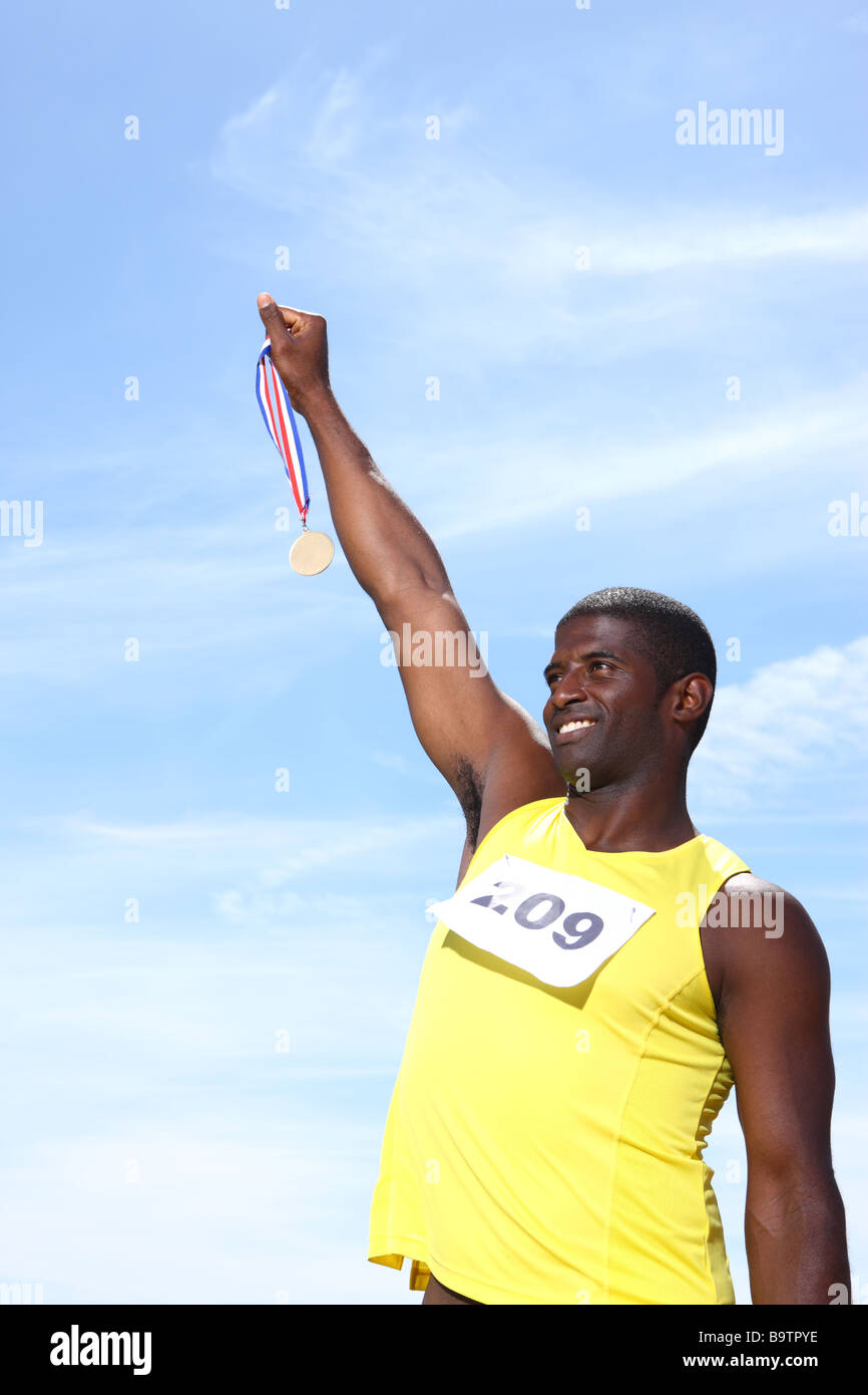 Athlete celebrating with gold medal Stock Photo - Alamy