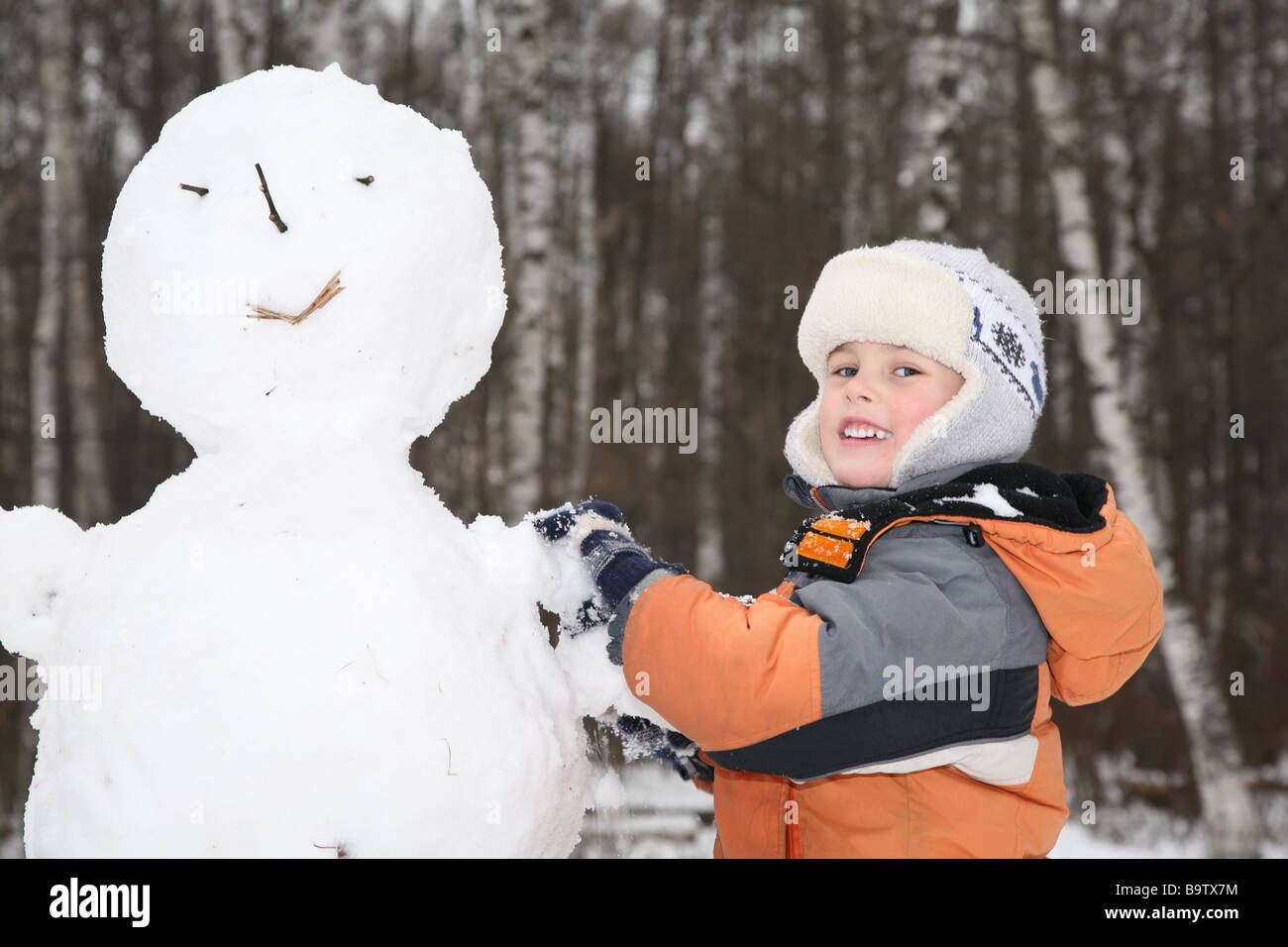 boy makes snowman 2 Stock Photo - Alamy