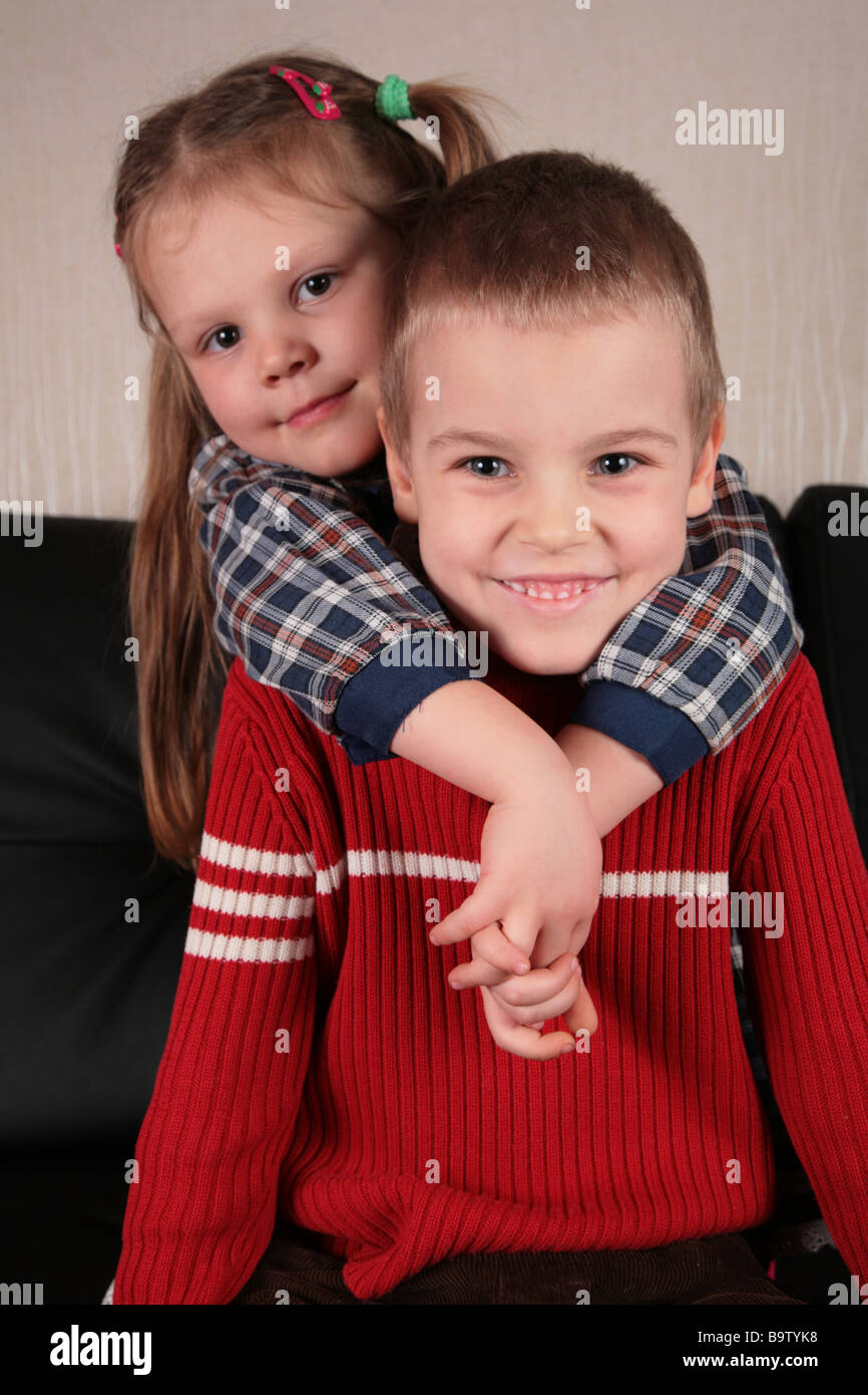 girl embraces boy for the neck on sofa Stock Photo - Alamy