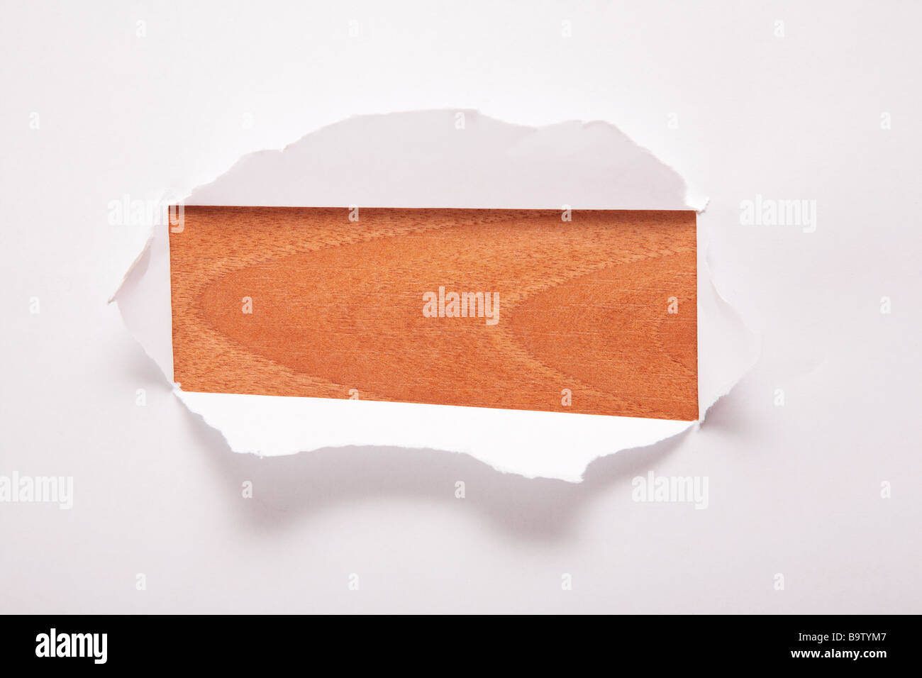 the sheet of paper with the rectangular hole against the wooden ...