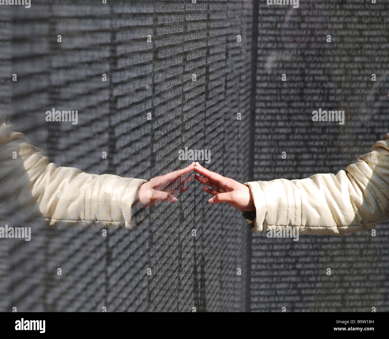 A hand tenderly touching a name on the Vietnam War Memorial in ...