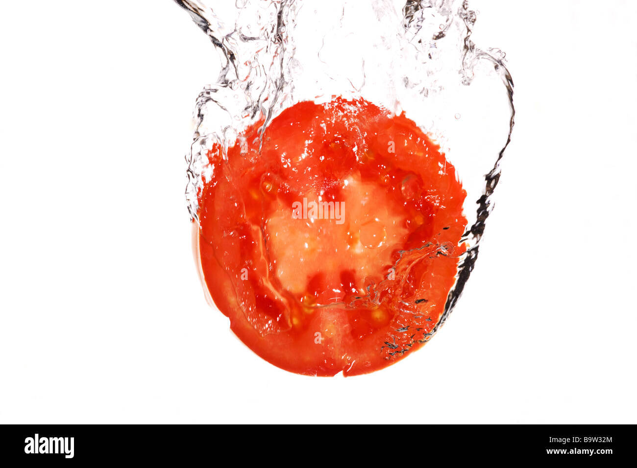 Tomato slice dropped in to water Stock Photo - Alamy