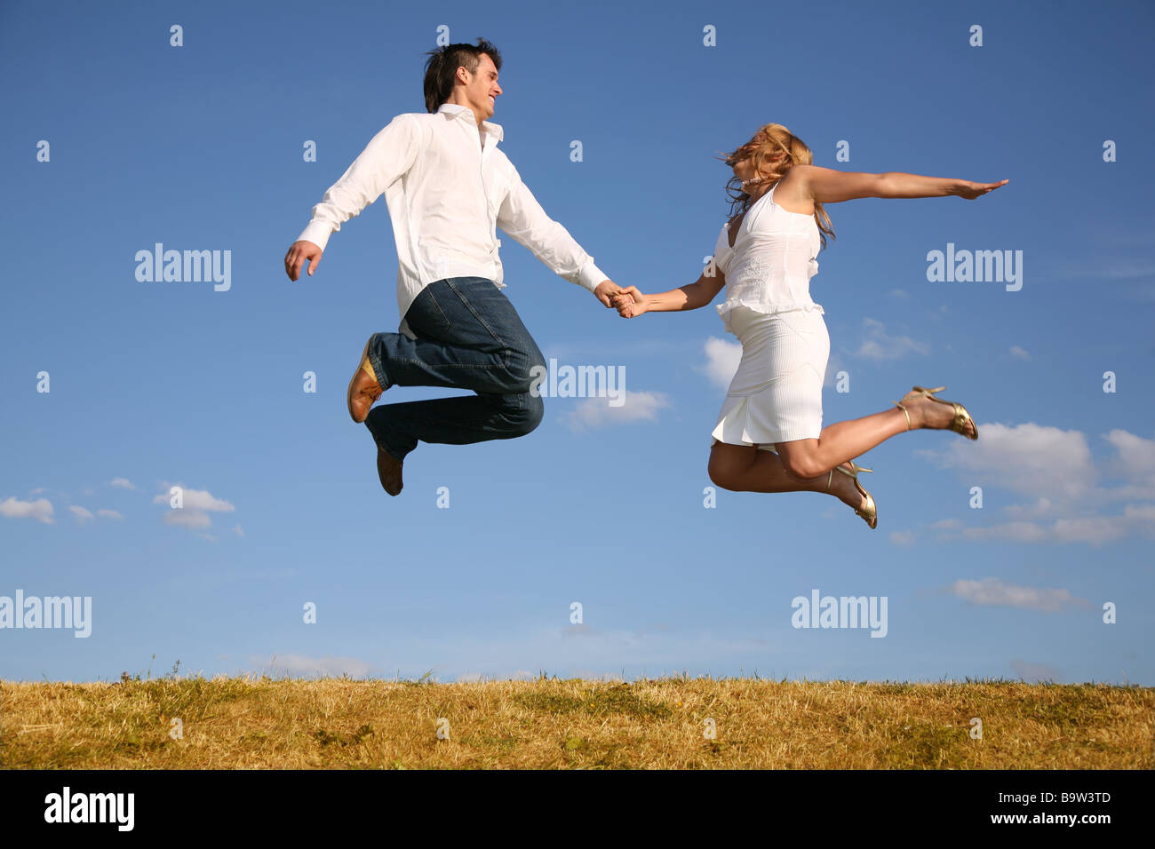 couple jump on meadow Stock Photo - Alamy