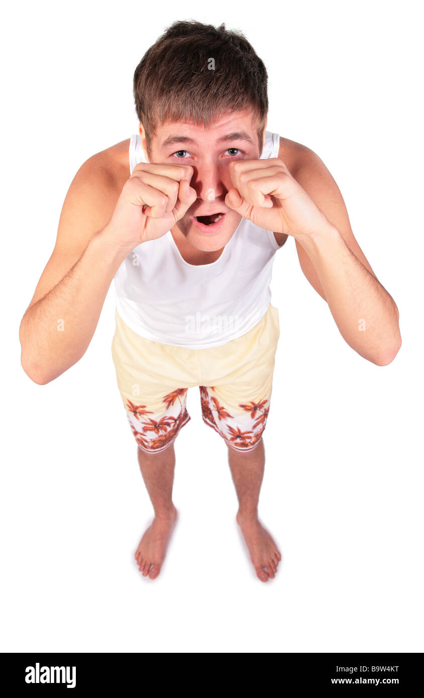 young man in shorts rubs eyes Stock Photo - Alamy