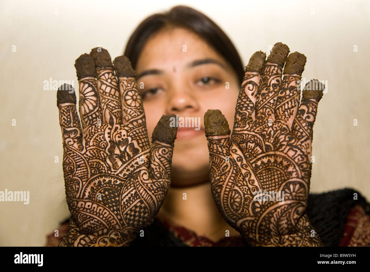 A bride's best friend shows off the fresh henna patterns on her hands ...