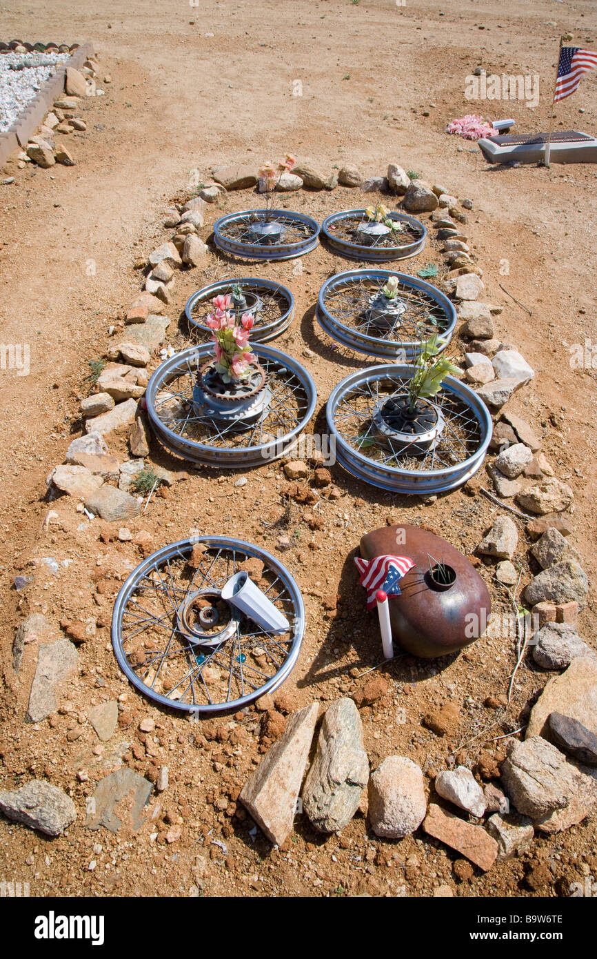 Desert graveyard with grave showing the remains of a Harley Davidson ...