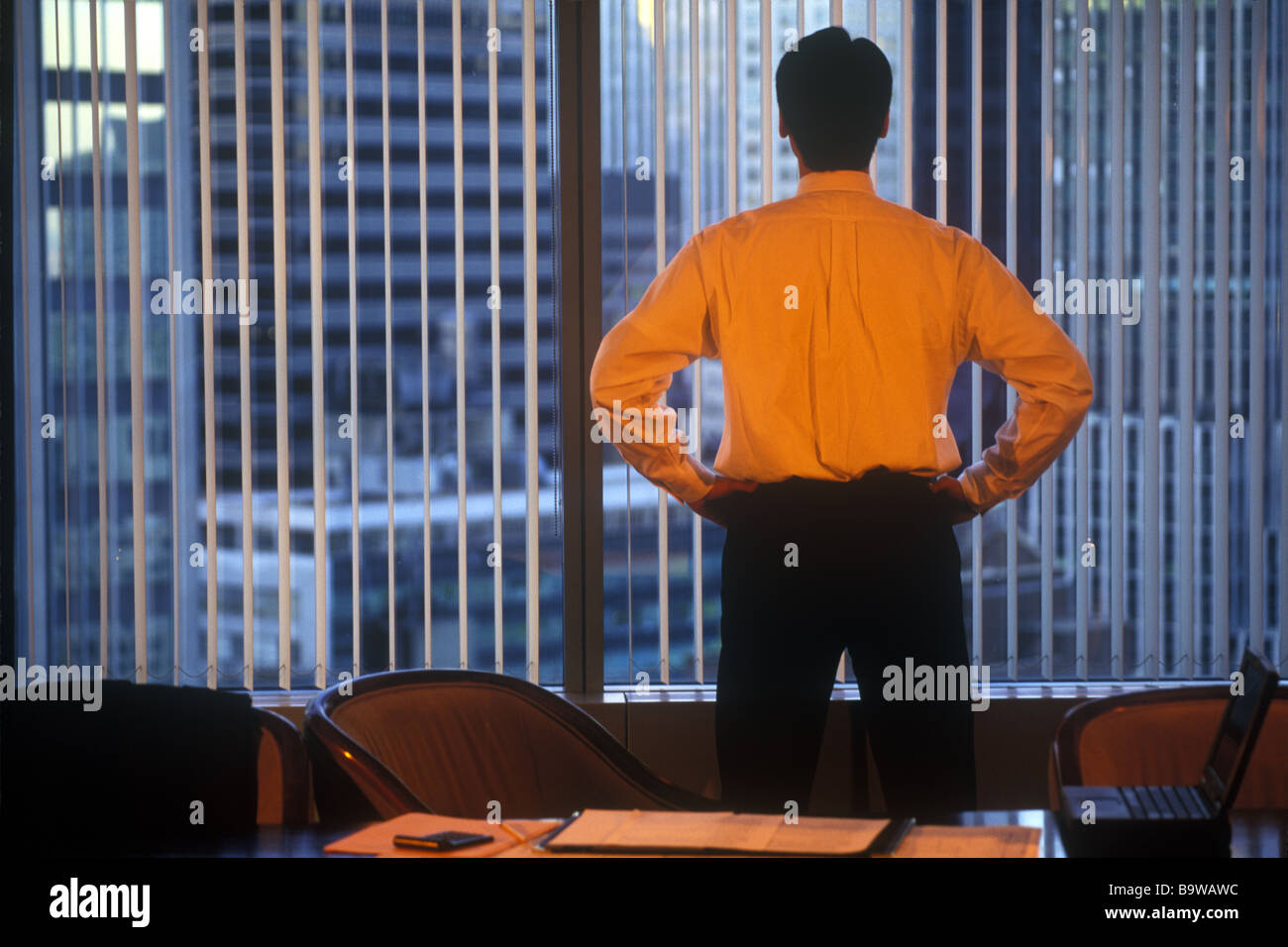 ASIAN OFFICE WORKER STANDING LOOKING OUT WINDOW IN MEETING ROOM Stock ...