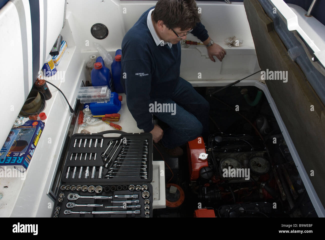 A man working on the engines in a motor cruiser boat Stock Photo - Alamy