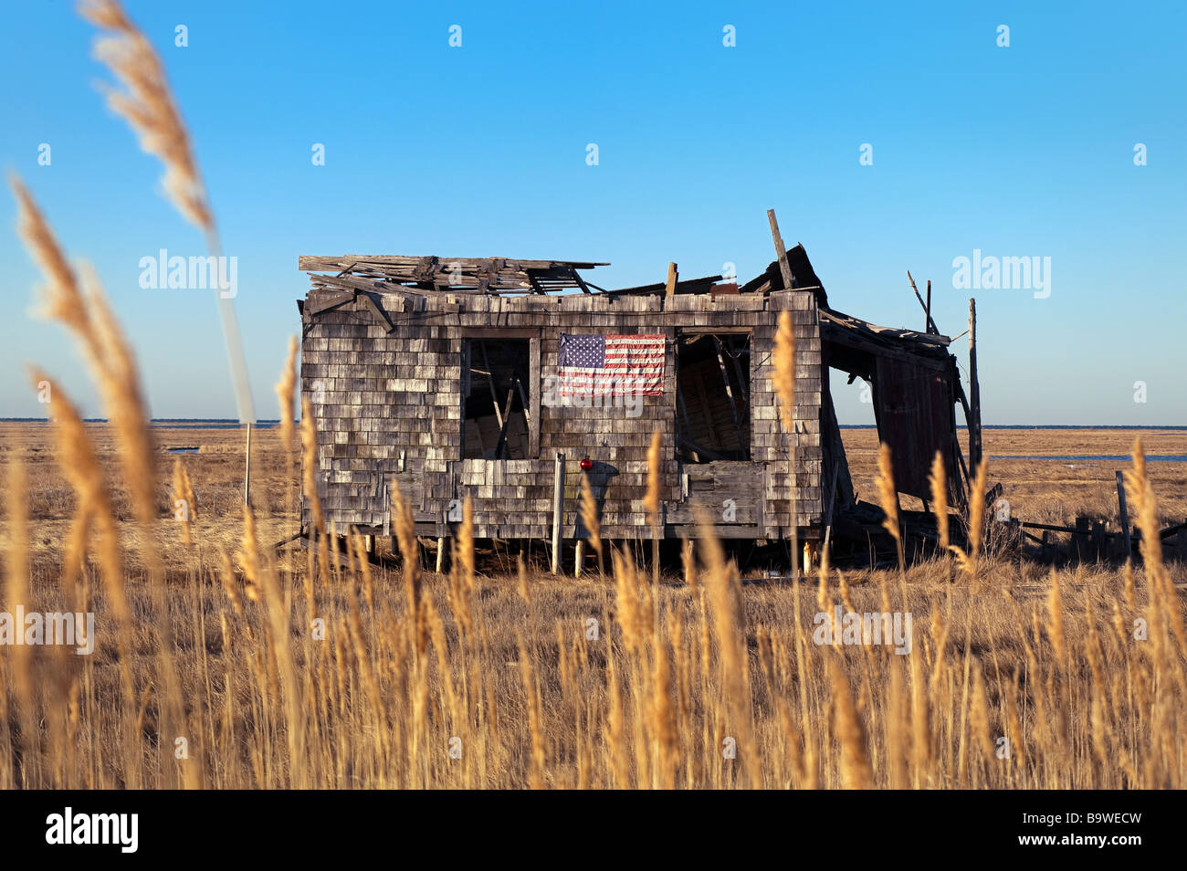 Ruined and abandoned shack with American flag and Christmas wreath ...