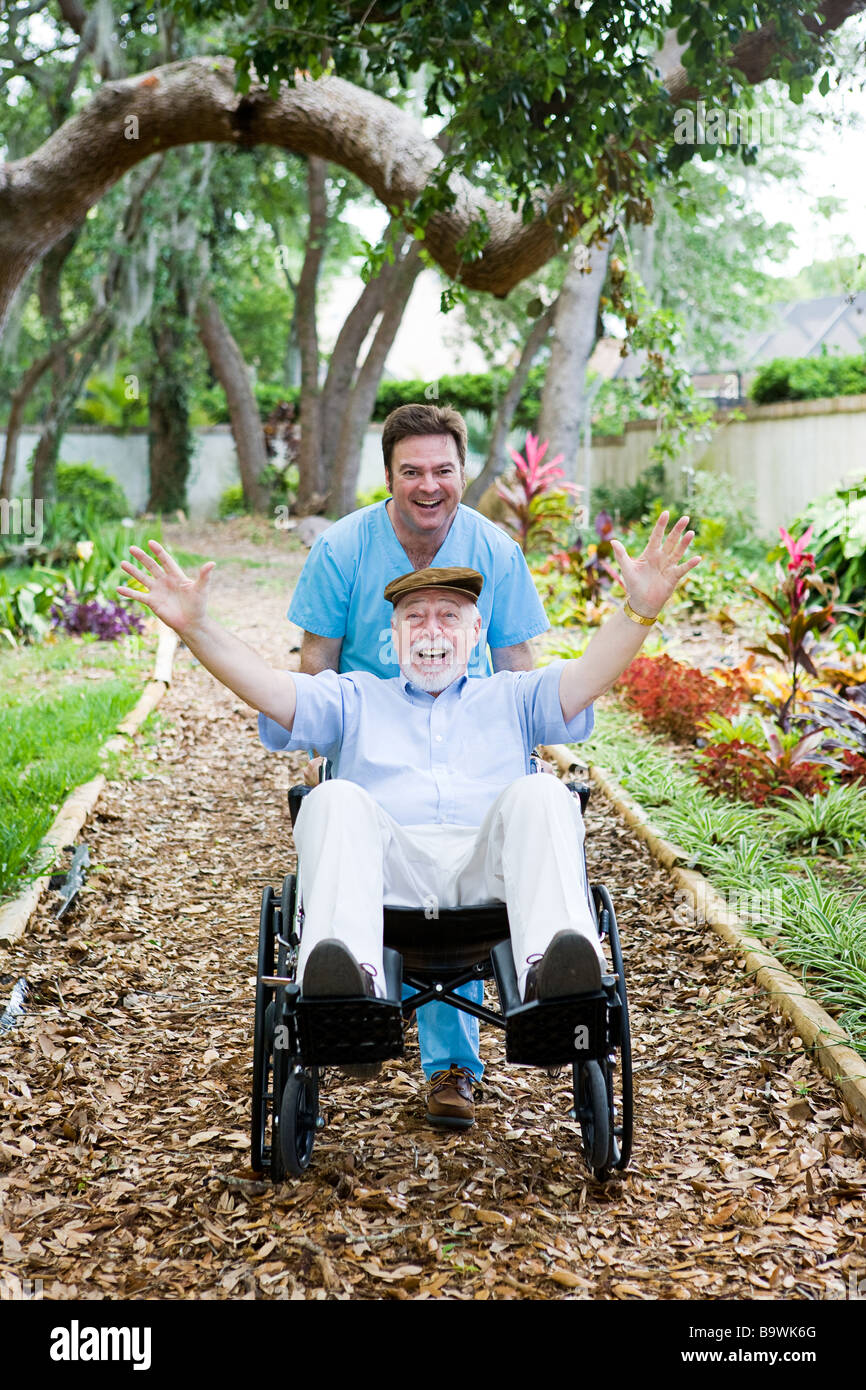 Caring nursing home orderly pops a wheelie with an elderly man s ...