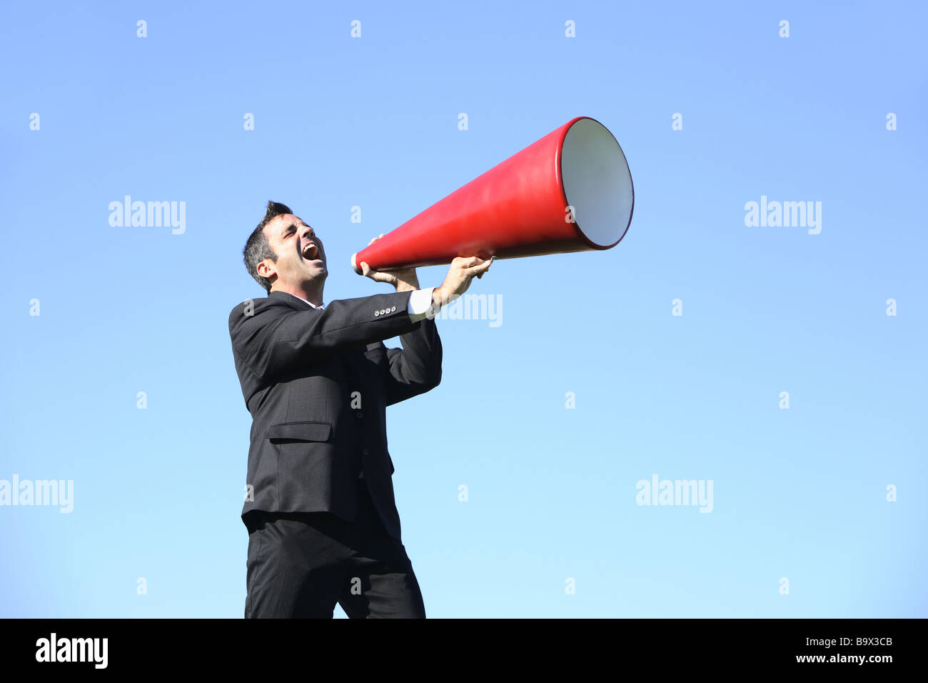Businessman outdoors with megaphone Stock Photo - Alamy